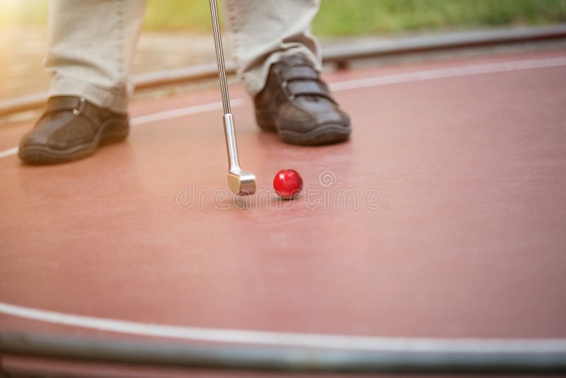 Man is Putting a Red Golf Ball with His Iron Racket Stock Image - Image ...
