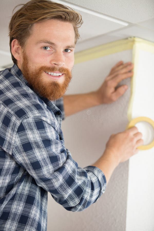 Man putting tape on wall stock image. Image of handyman - 286471691