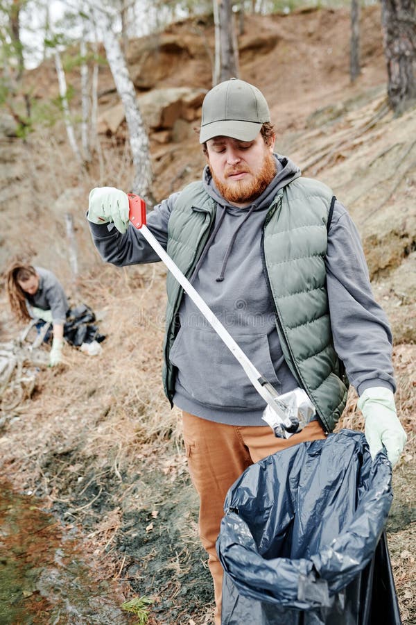 Man Putting Trash in Bag stock image. Image of forest - 268523369