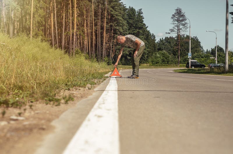 Man Putting Triangle Warning Caution Sign on Road Side Stock Photo ...