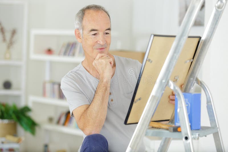 Man putting up frame stock photo. Image of hand, mechanic - 298847814