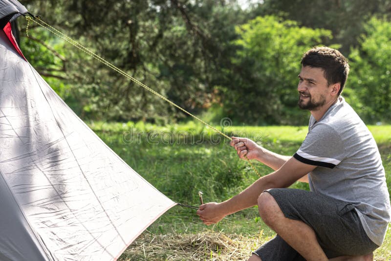 Man Putting Up a Tent in the Forest Stock Photo - Image of camp ...