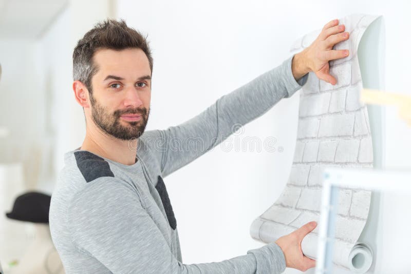 Man Putting Wall Paper on Wall Stock Image - Image of friendly, paper ...