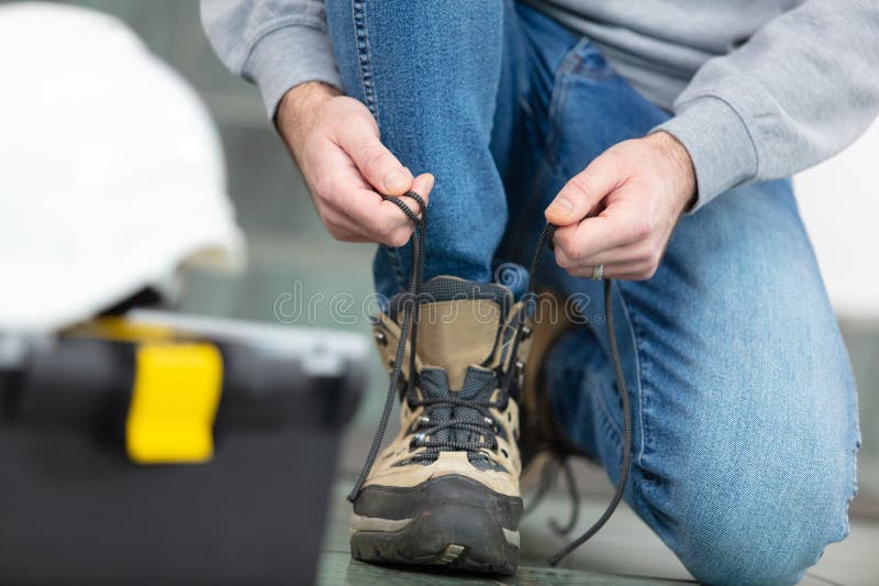 Man putting workboots on stock image. Image of feet - 331786617
