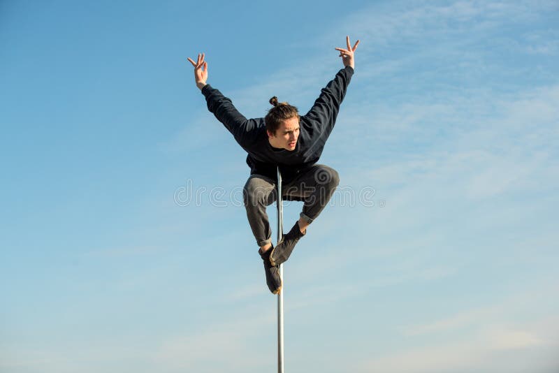 The Man on the Pylon Does the Exercise Against the Backdrop of Blue Sky ...
