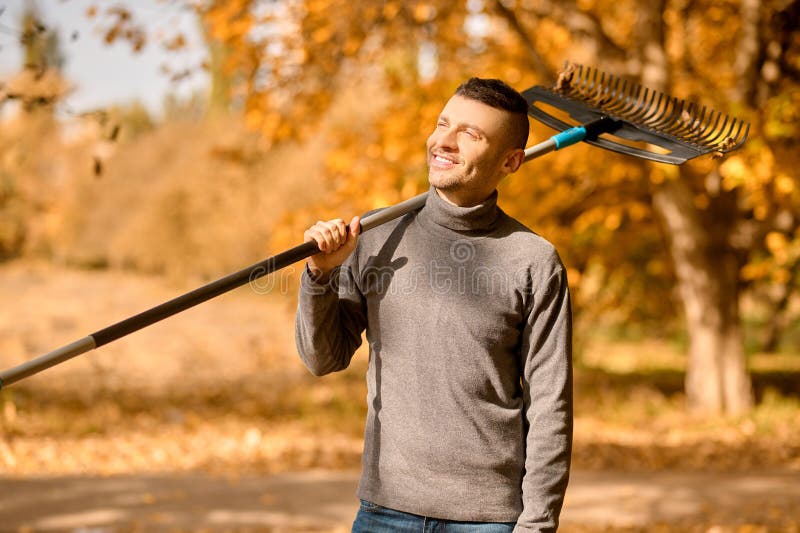 A Man with a Rake Standing in the Park Stock Photo - Image of yellow ...