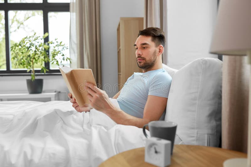 Man Reading Book in Bed at Home Stock Image - Image of reader, male ...
