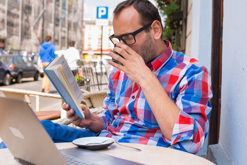 Man is Reading a Book in Cafe. he is Drinking Coffee. Stock Image ...