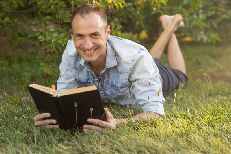 Man Reading a Book on the Grass Stock Image - Image of outdoor, casual ...