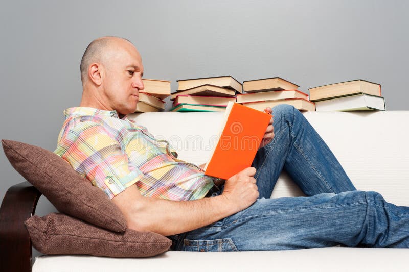 Man reading book at home stock image. Image of mature - 24478449