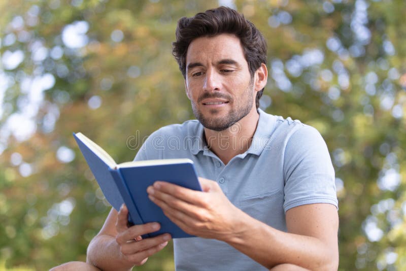 Man reading book in park stock photo. Image of cute - 234014442