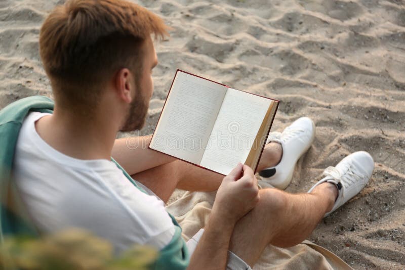 Young Man Reading Book on Sandy Beach, Back View Stock Photo - Image of ...