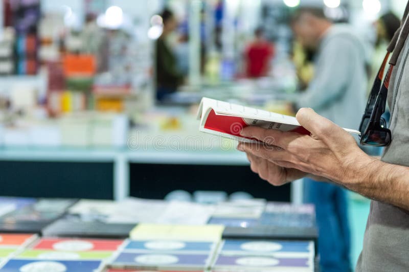 Man Reading a Book at the Stand in a Book Fair Stock Image - Image of ...