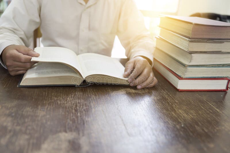 Man Reading Book with Textbook Stack on Wooden Desk Stock Photo - Image ...