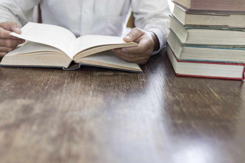 Man Reading Book with Textbook Stack on Wooden Desk Stock Photo - Image ...