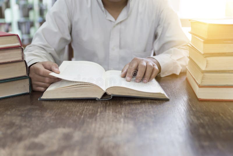 Man Reading Book with Textbook Stack on Wooden Desk Stock Photo - Image ...