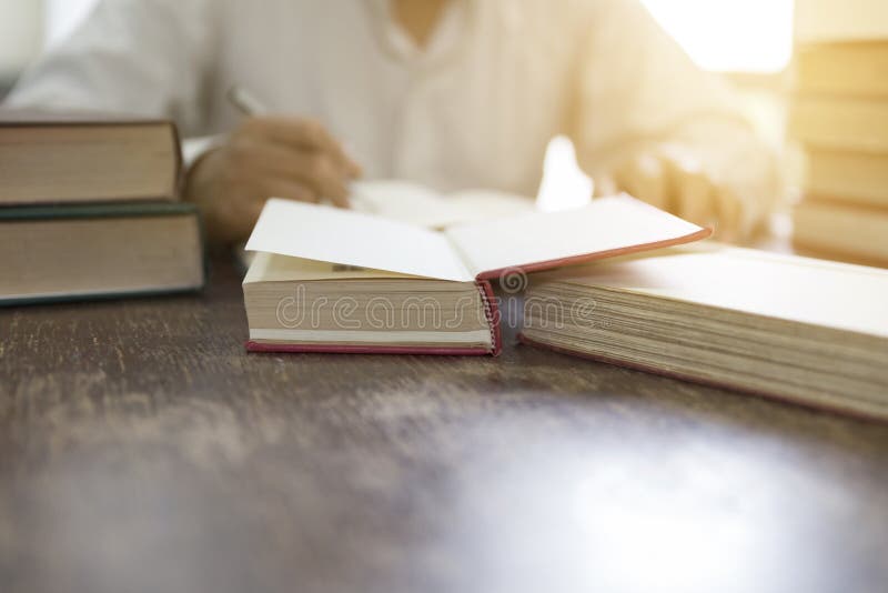 Man Reading Book with Textbook Stack on Wooden Desk Stock Image - Image ...