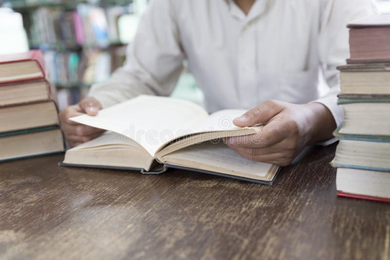 Man Reading Book with Textbook Stack on Wooden Desk Stock Image - Image ...