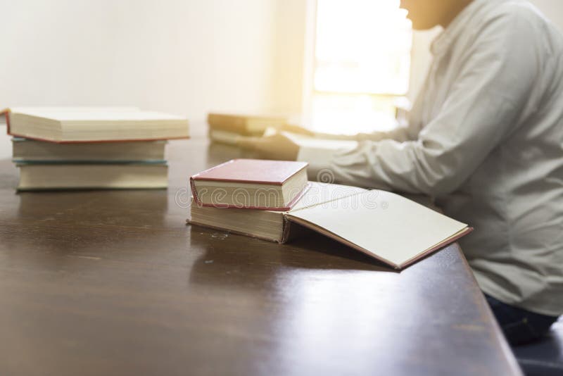 Man Reading Book with Textbook Stack on Wooden Desk Stock Image - Image ...