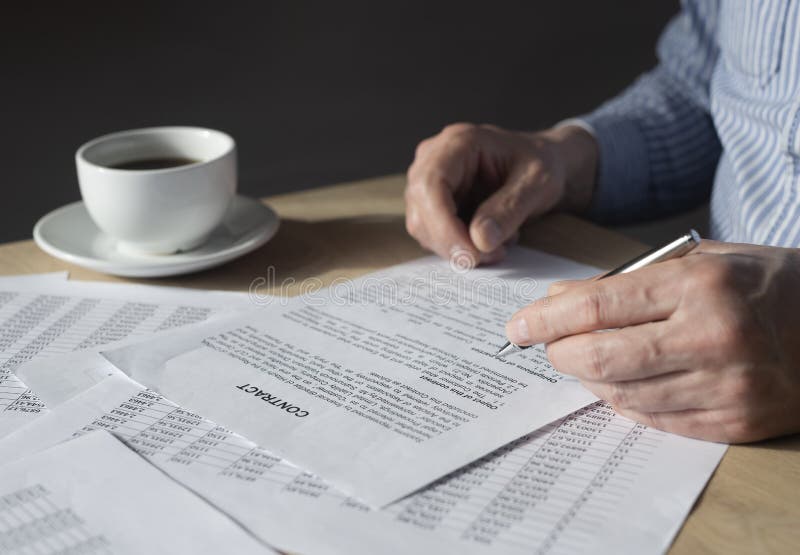 Man Reading Contract To Sign it at Office Desk Stock Photo - Image of ...
