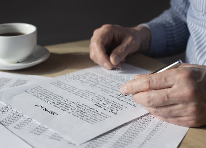 Man Reading Contract To Sign it at Office Desk Stock Photo - Image of ...