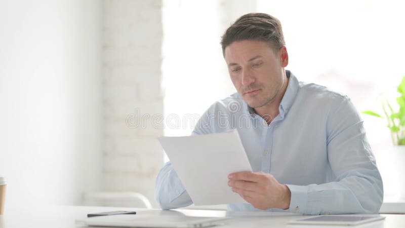 Man Reading Documents while Sitting in Office Stock Image - Image of ...