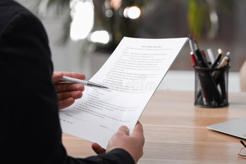 Man Reading Employment Agreement at Table in Office, Closeup. Signing ...
