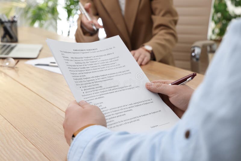 Man Reading Employment Agreement at Table in Office, Closeup. Signing ...