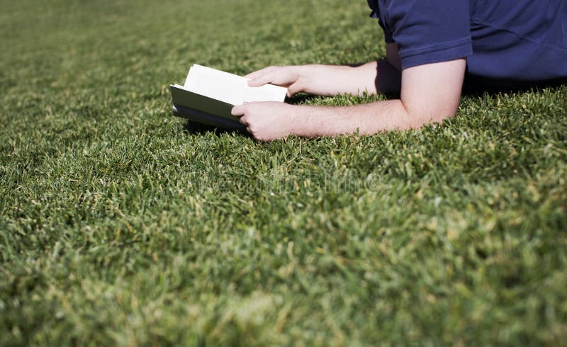 Man reading on grass stock photo. Image of smile, youth - 7835818
