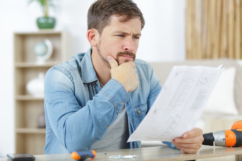 Man Reading Instruction and Putting Together Furniture Stock Photo ...