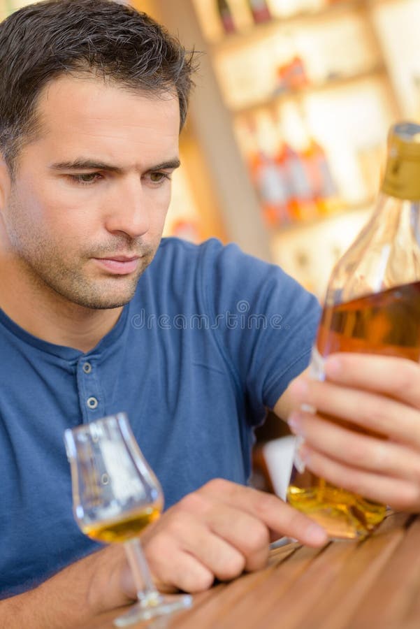 Man Reading Label on Bottle Brandy Stock Photo - Image of young, whisky ...