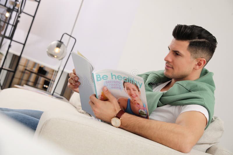 Man Reading Magazine on Sofa in Room Stock Photo - Image of indoors ...