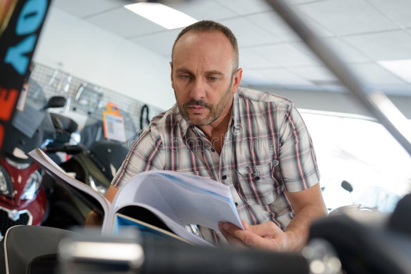 Man reading manual scooter stock image. Image of acquire - 308543415