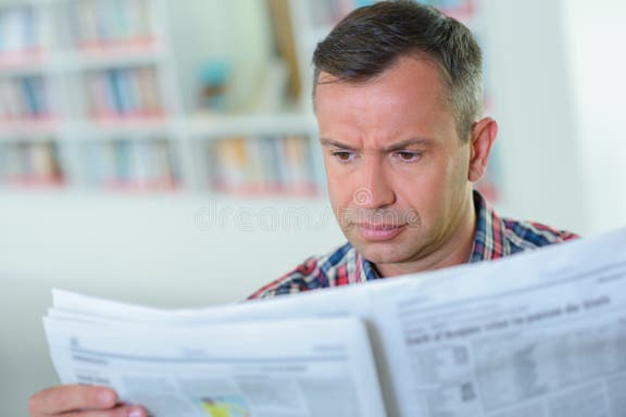 Man Reading Newspaper Intently Stock Photo - Image of middleage ...
