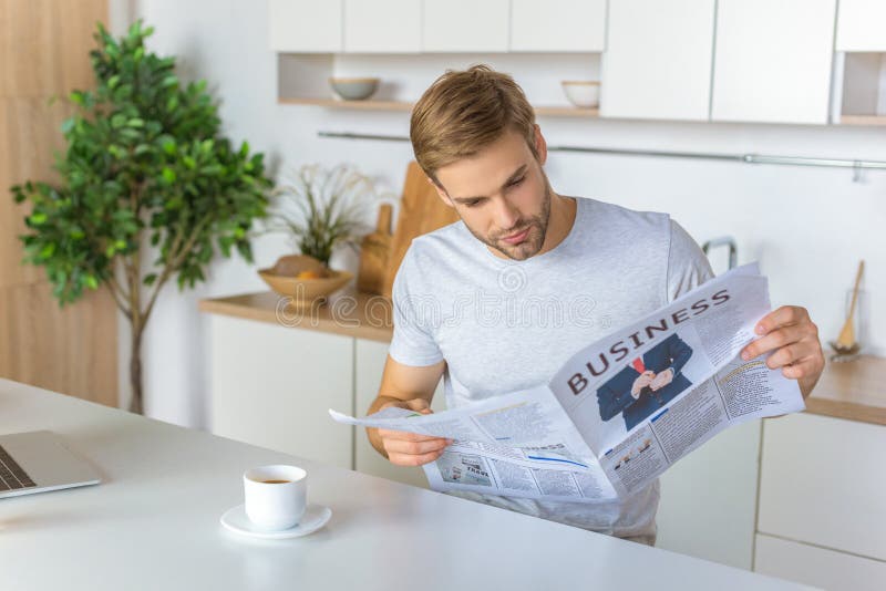 Man Reading Newspaper during Morning Time at Kitchen Table with Coffee ...