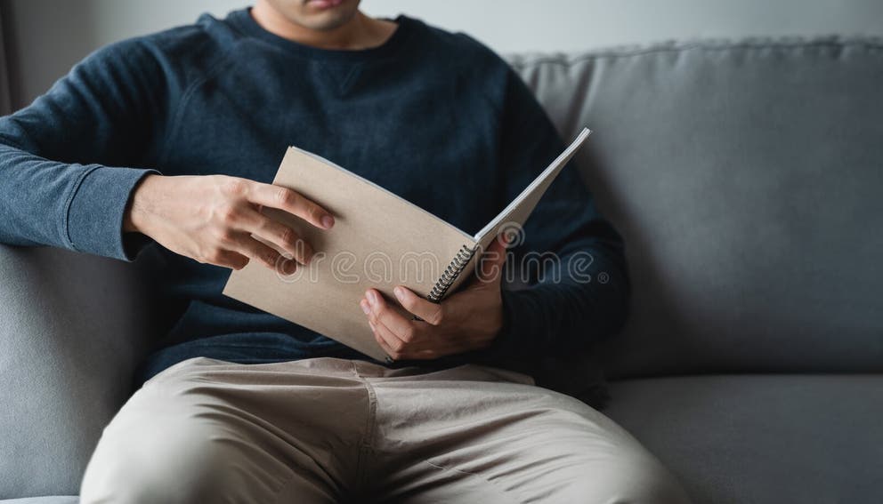 Man Reading the Notebook Sitting on the Sofa at Home Stock Image ...