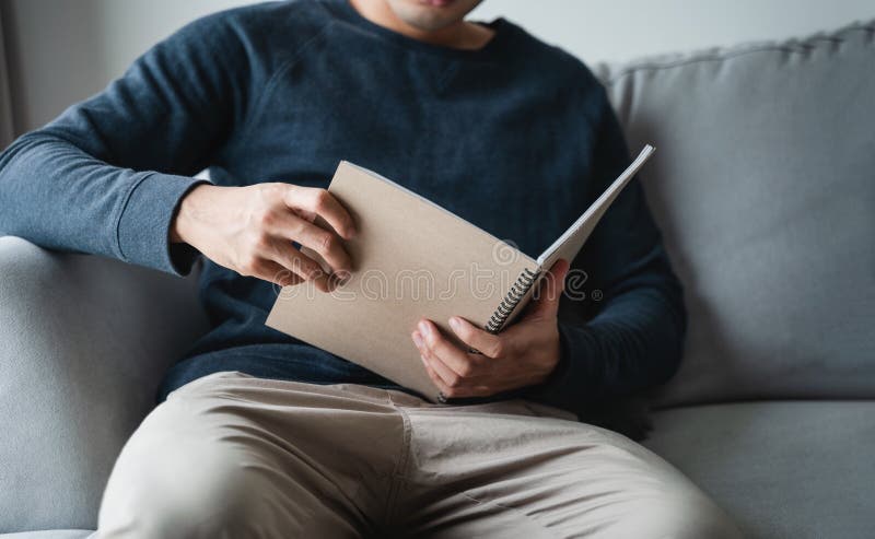 Man Reading the Notebook Sitting on the Sofa at Home Stock Image ...