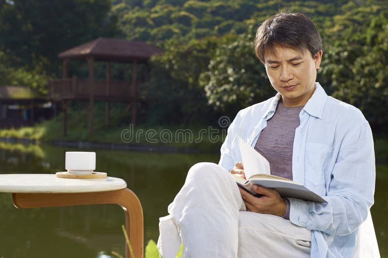 Man Reading Book beside Lake in Morning Stock Image - Image of morning ...