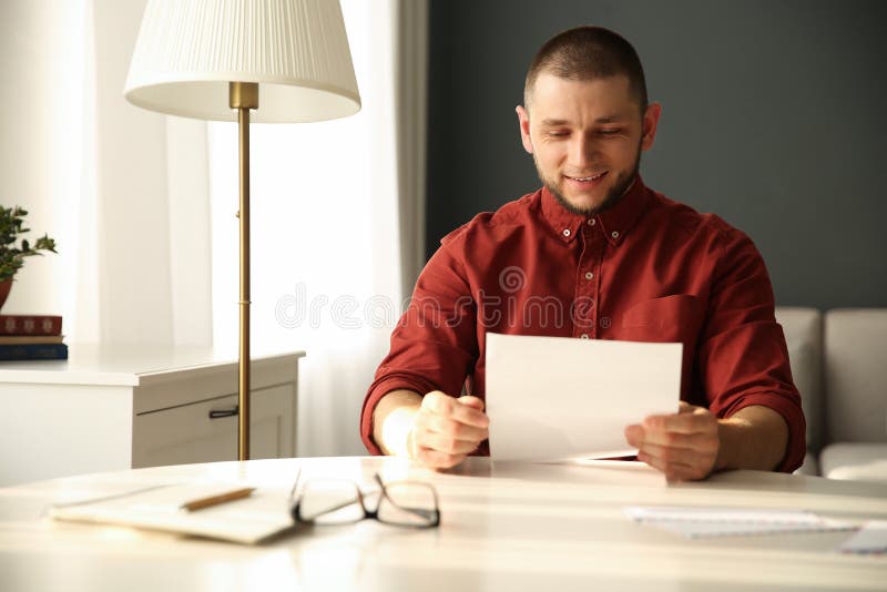 Man Reading Paper Letter at White Table in Room Stock Image - Image of ...