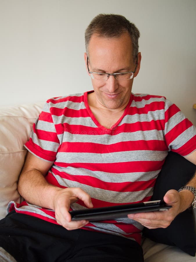 Man with on a tablet stock image. Image of reading, couch - 30181411