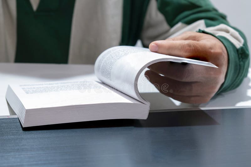 A Man is Ready a Book on the Table Stock Image - Image of laptop ...