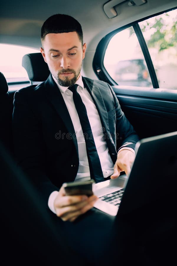 Business Man in Rear of the Car. Typing Text Message on Cell Phone ...