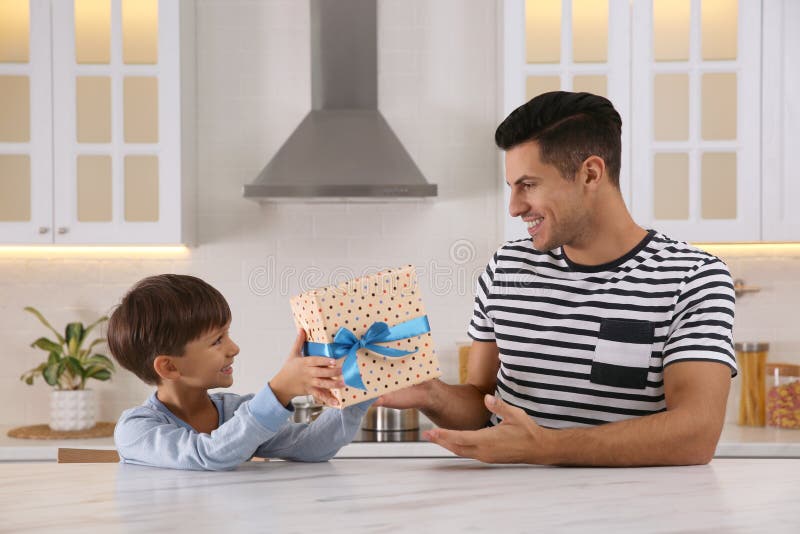 Man Receiving Gift for Father`s Day from His Son in Kitchen Stock Photo ...