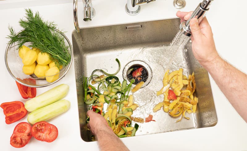 A Man Recycles Food Waste Using a Modern Kitchen Disposer Stock Photo ...