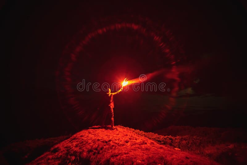 The Man with a Red Firework Stick Standing on a Mountain. Evening Night ...