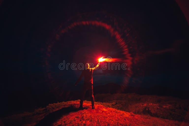 The Man with a Red Firework Stick Standing on a Mountain. Evening Night ...