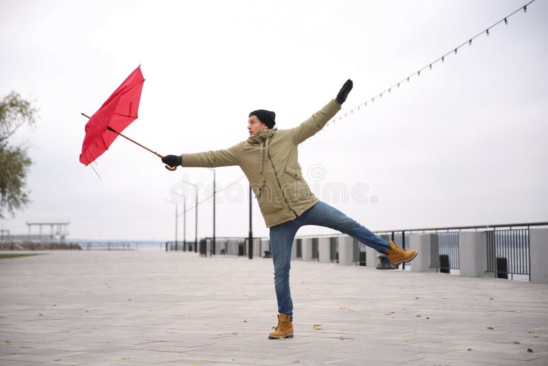 Man with Red Umbrella Caught in Gust of Wind Outdoors Stock Image ...