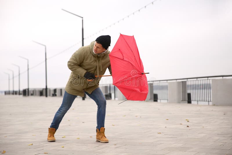 Man Holding Umbrella in Wind Stock Photo - Image of windy, holding: 5919854