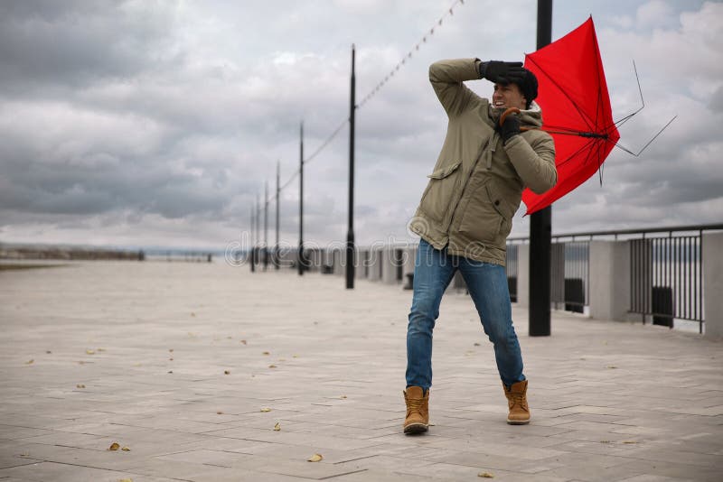 Man with Red Umbrella Caught in Gust of Wind Outdoors Stock Photo ...