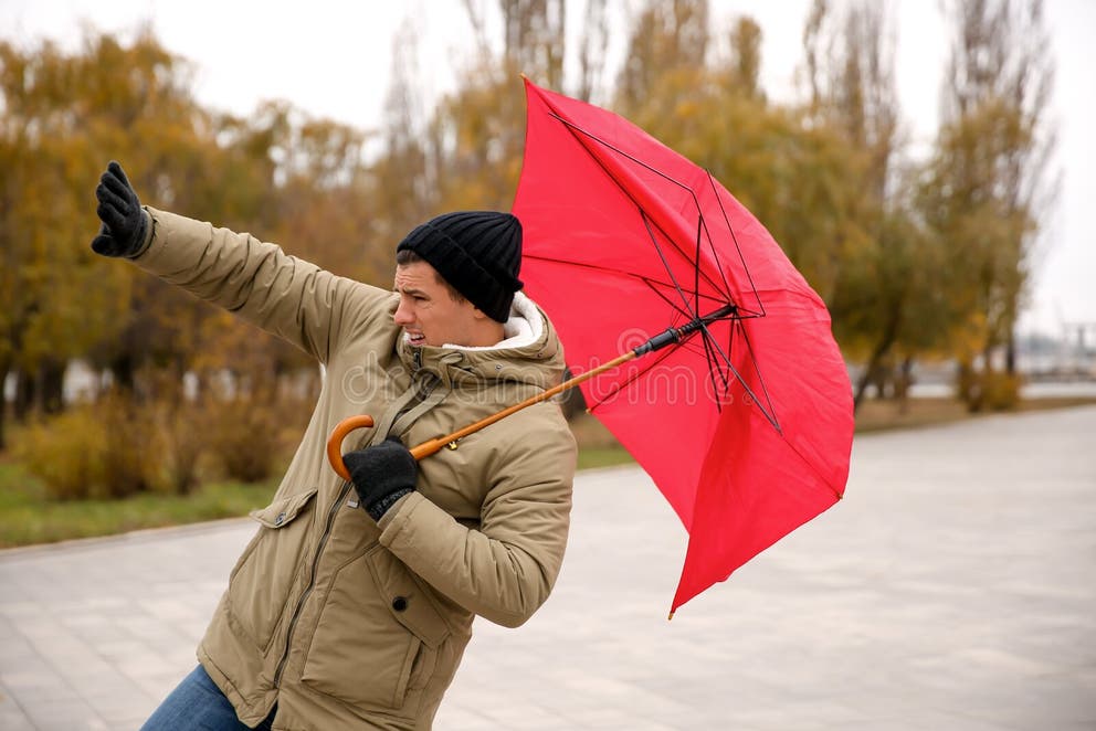Man with Red Umbrella Caught in Gust of Wind Outdoors Stock Image ...